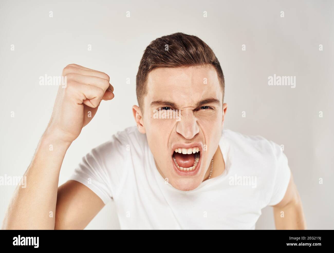 Crazy man gesturing with his hands on a light background Scream stress ...