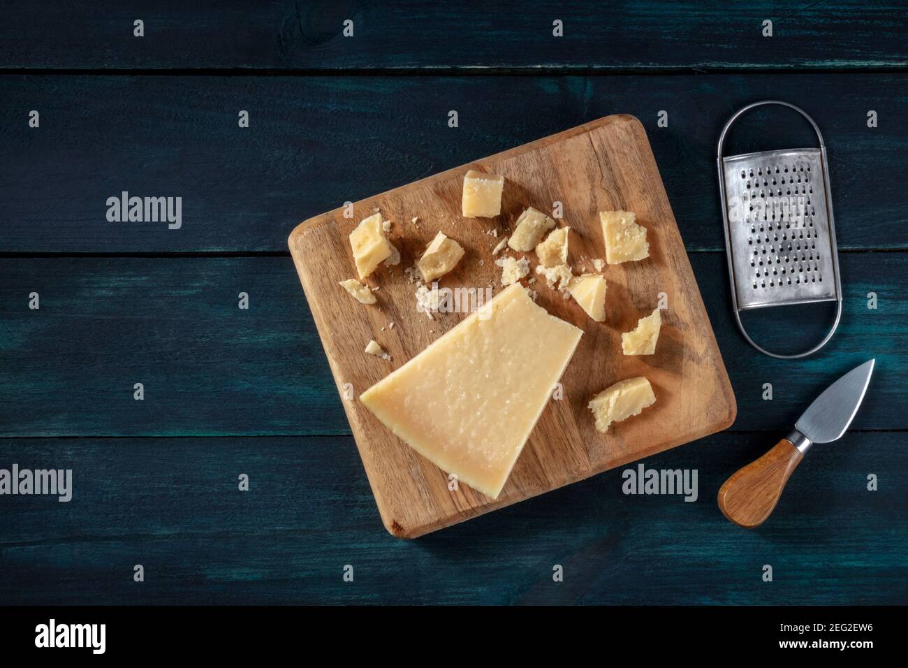 Crumbled Parmesan cheese with a knife and a grater, overhead shot on a ...