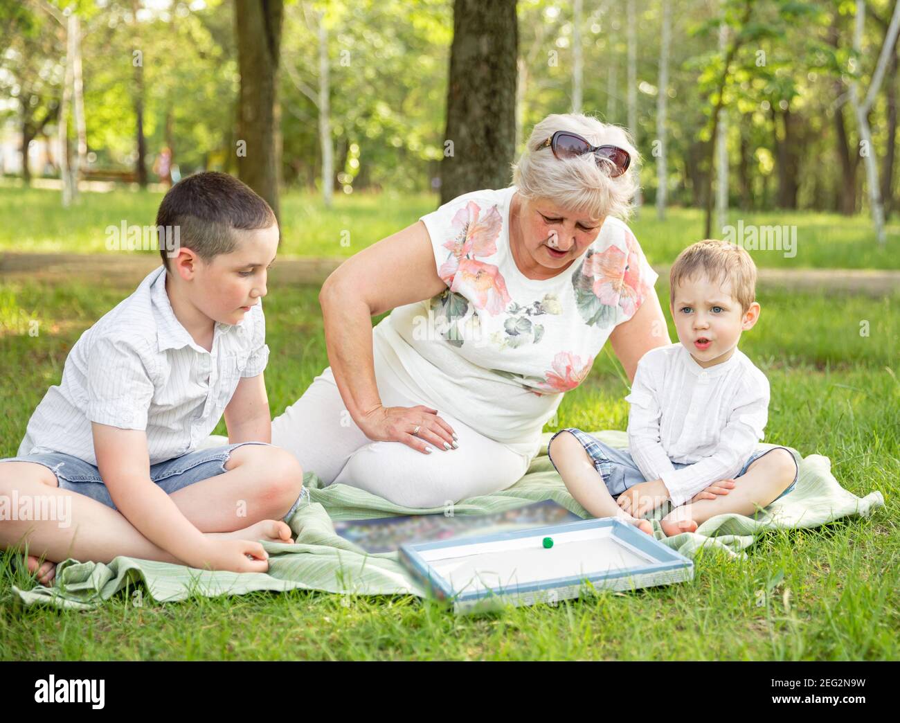 Grandmother playing with her grandchildren at nature. Happy moments ...