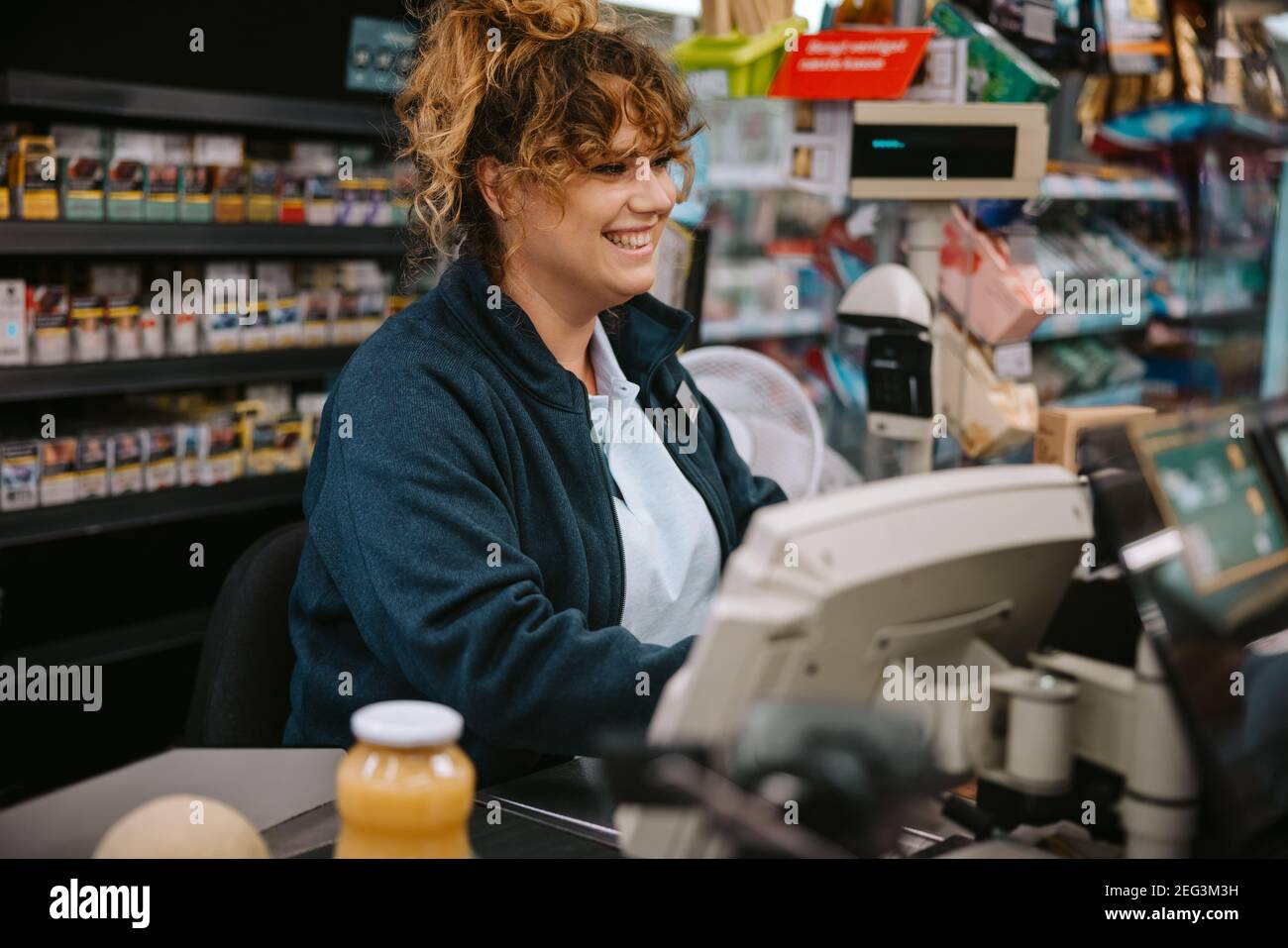 Female grocery store worker working at checkout counter. Woman cashier ...