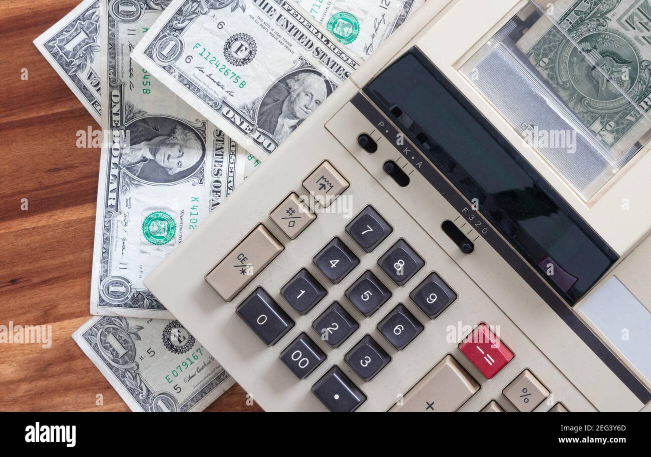 Old fashioned calculator and dollars on a desk Stock Photo - Alamy