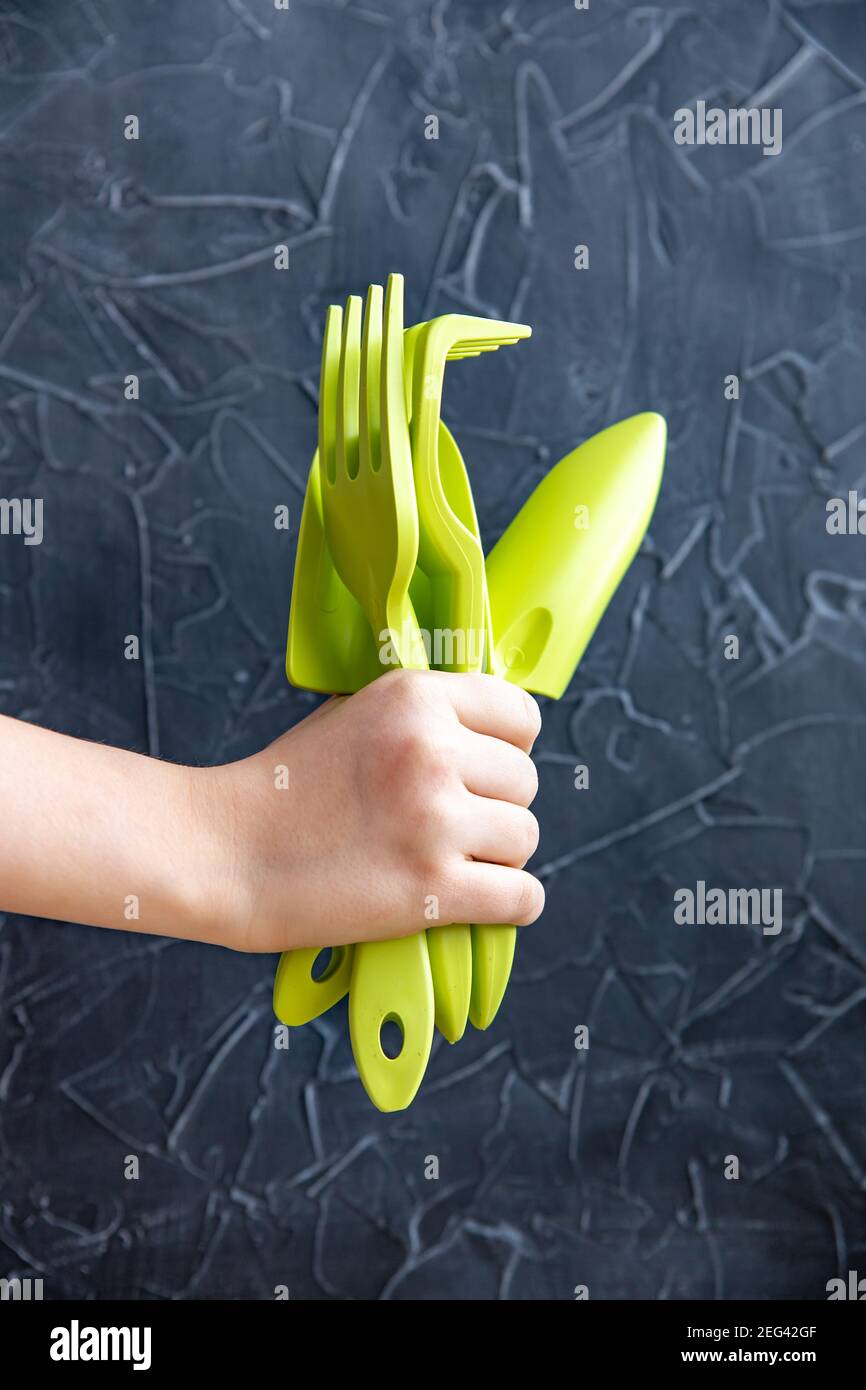 A set of gardening tools light green colors in hand on a black ...
