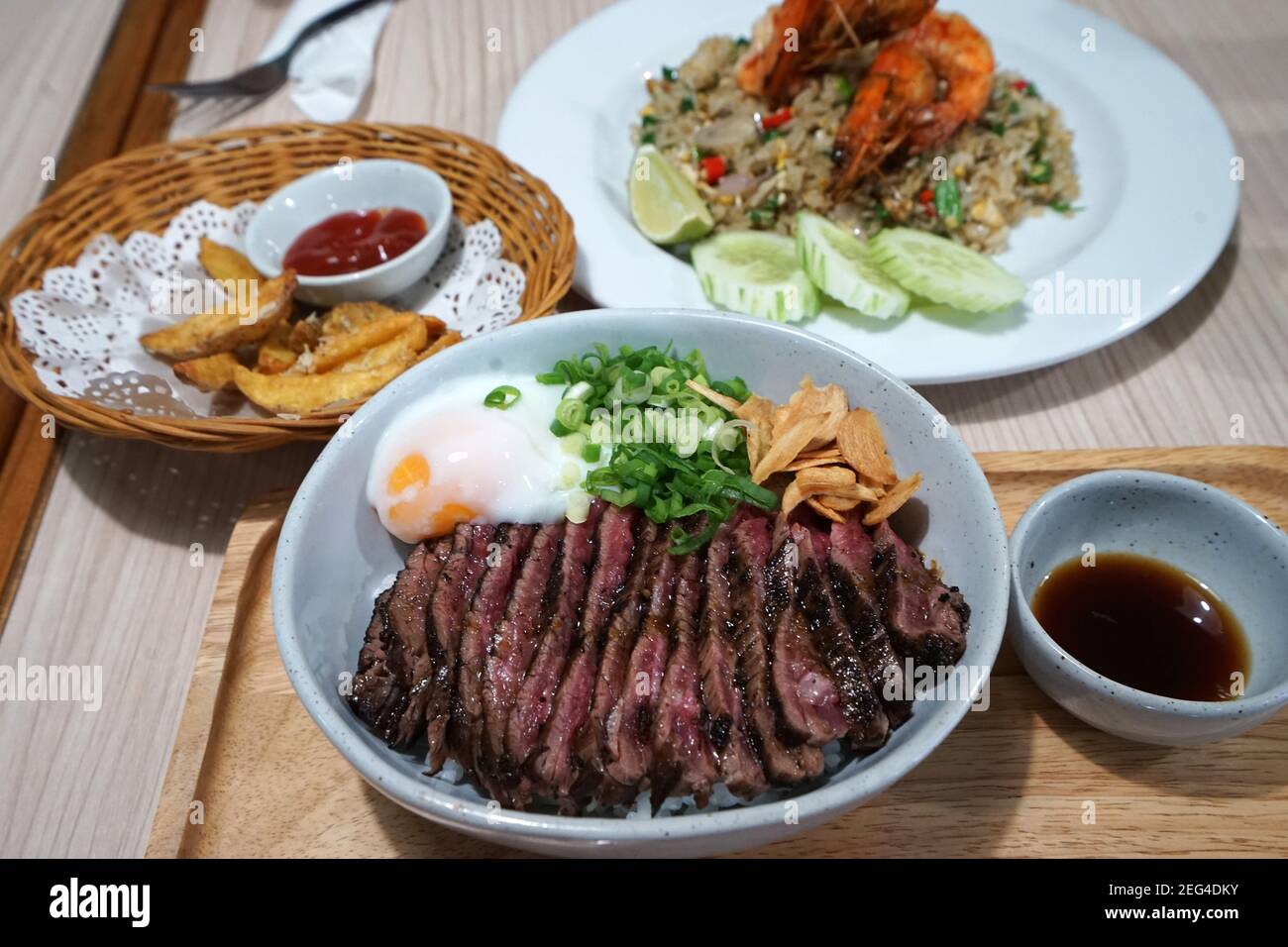 Wagyu beef rice served with stir fry shrimp rice and fried potato wedge ...