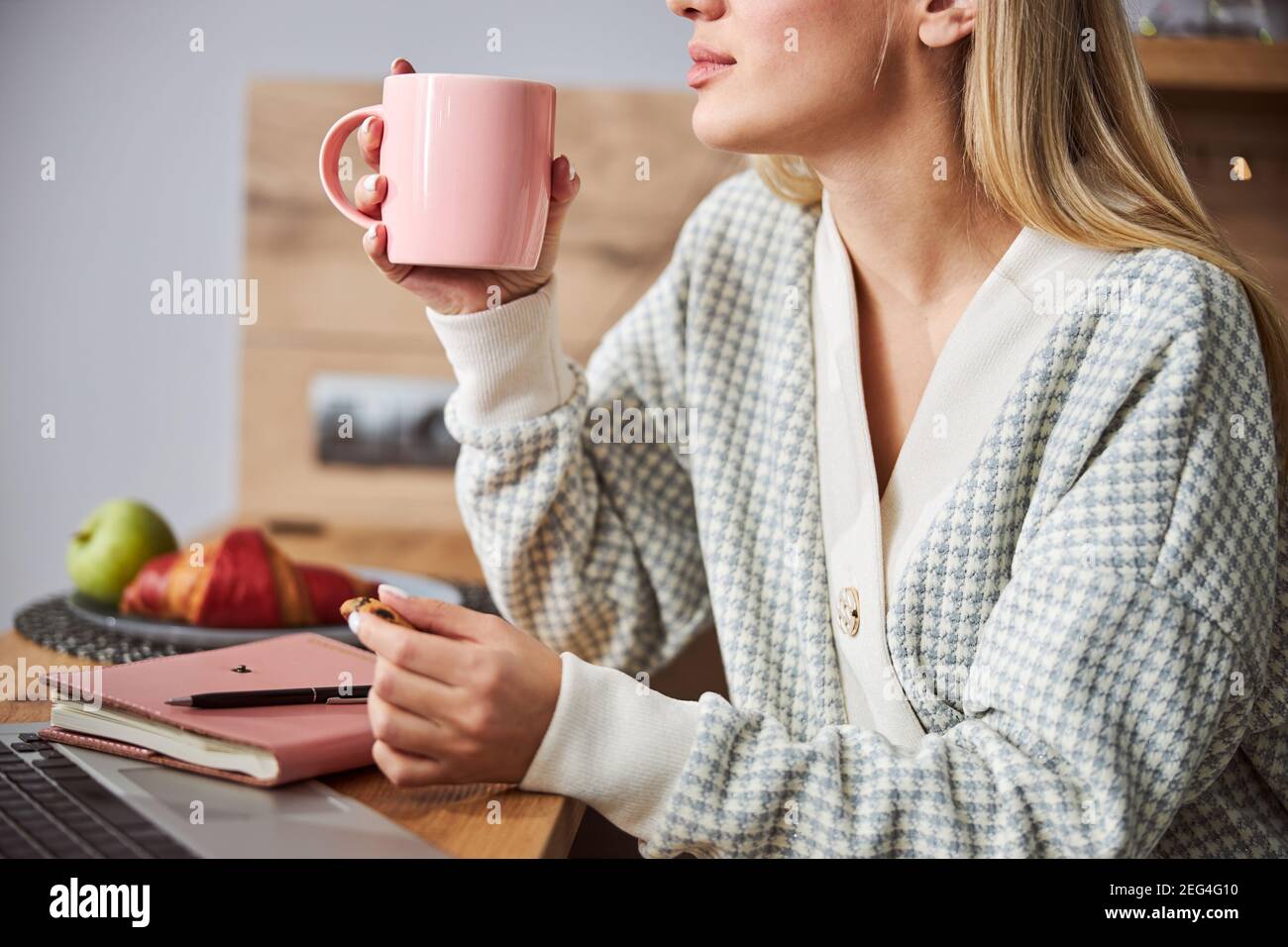 Female taking a sip of tea while holding cookie Stock Photo - Alamy