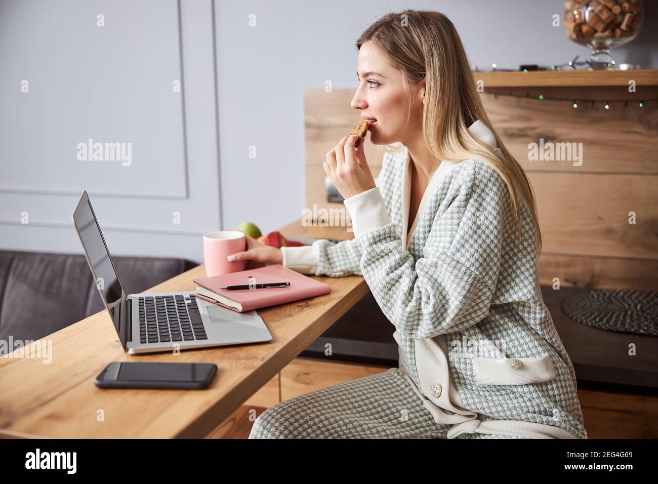 Lady taking a quick bite with a biscuit Stock Photo - Alamy