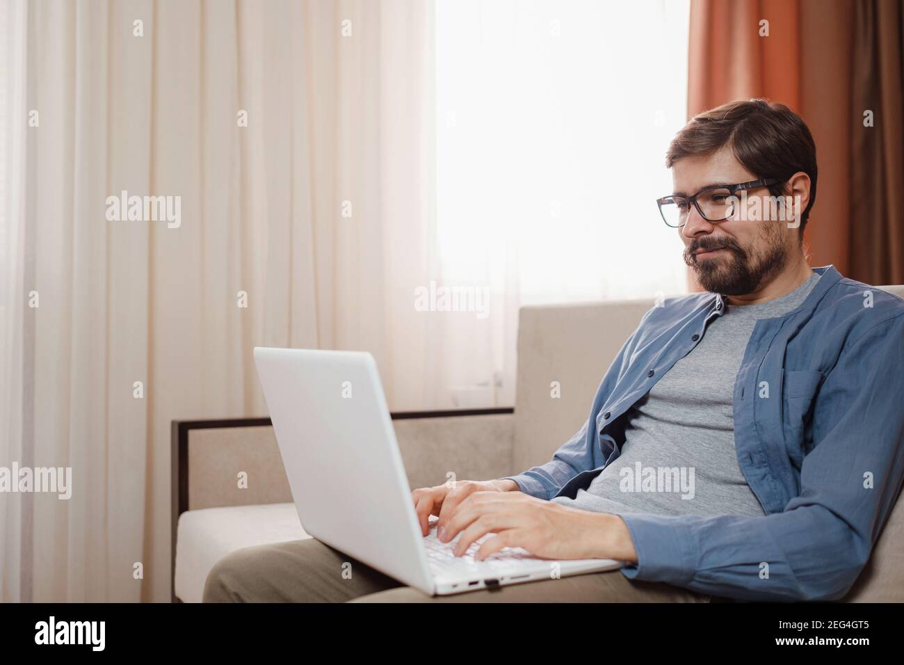 Handsome young man using laptop computer at home. Student men in his ...
