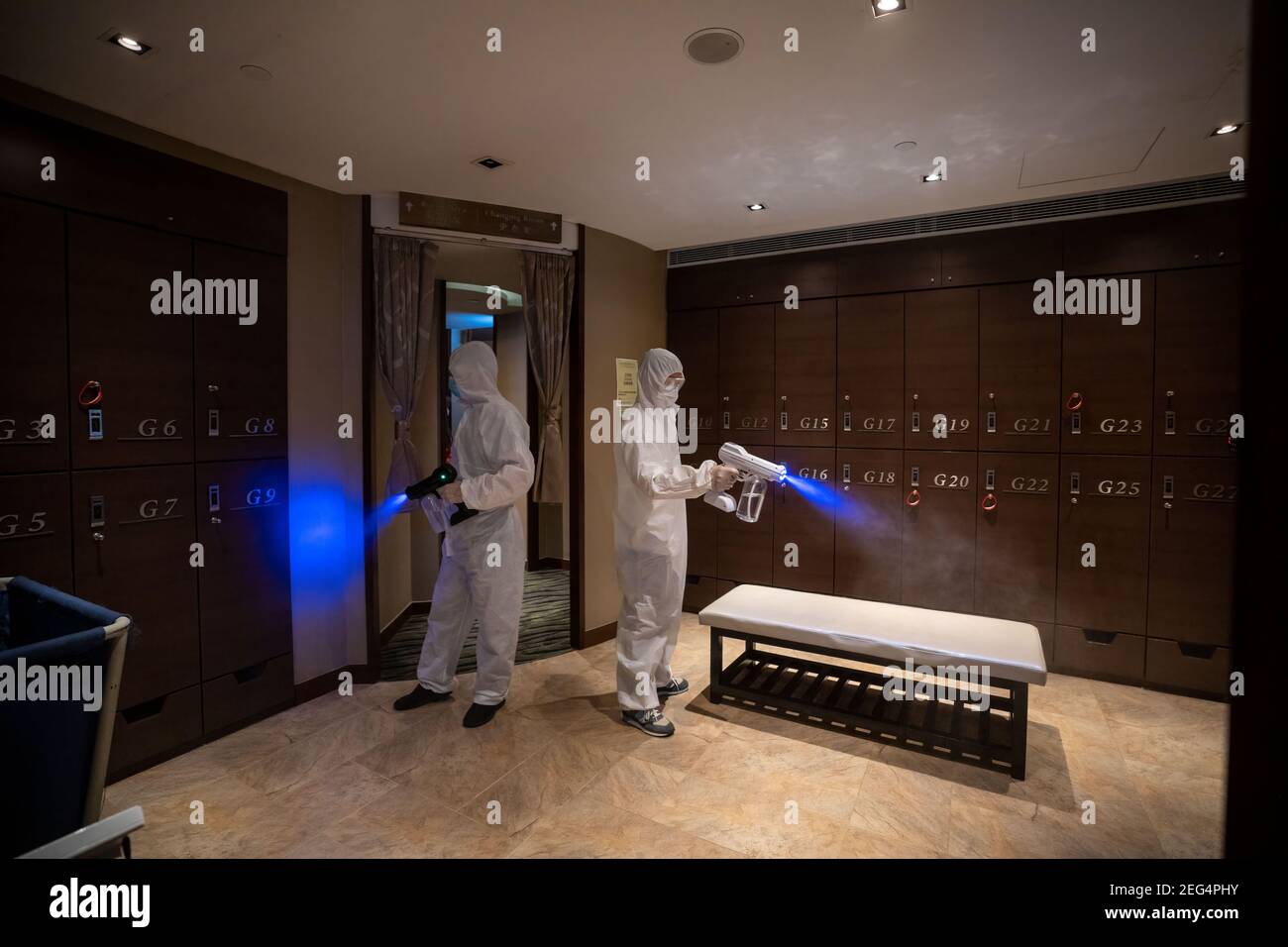 Employee wearing PPE (Personal Protective Equipment) spray disinfectant ...