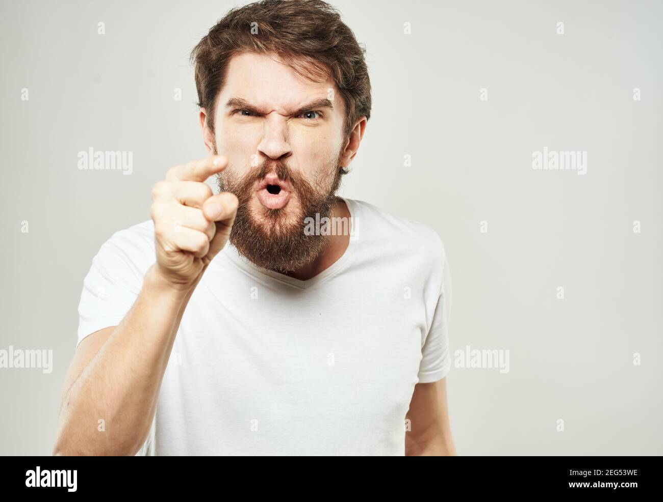 Aggressive man gestures with his hands on a light background stress ...