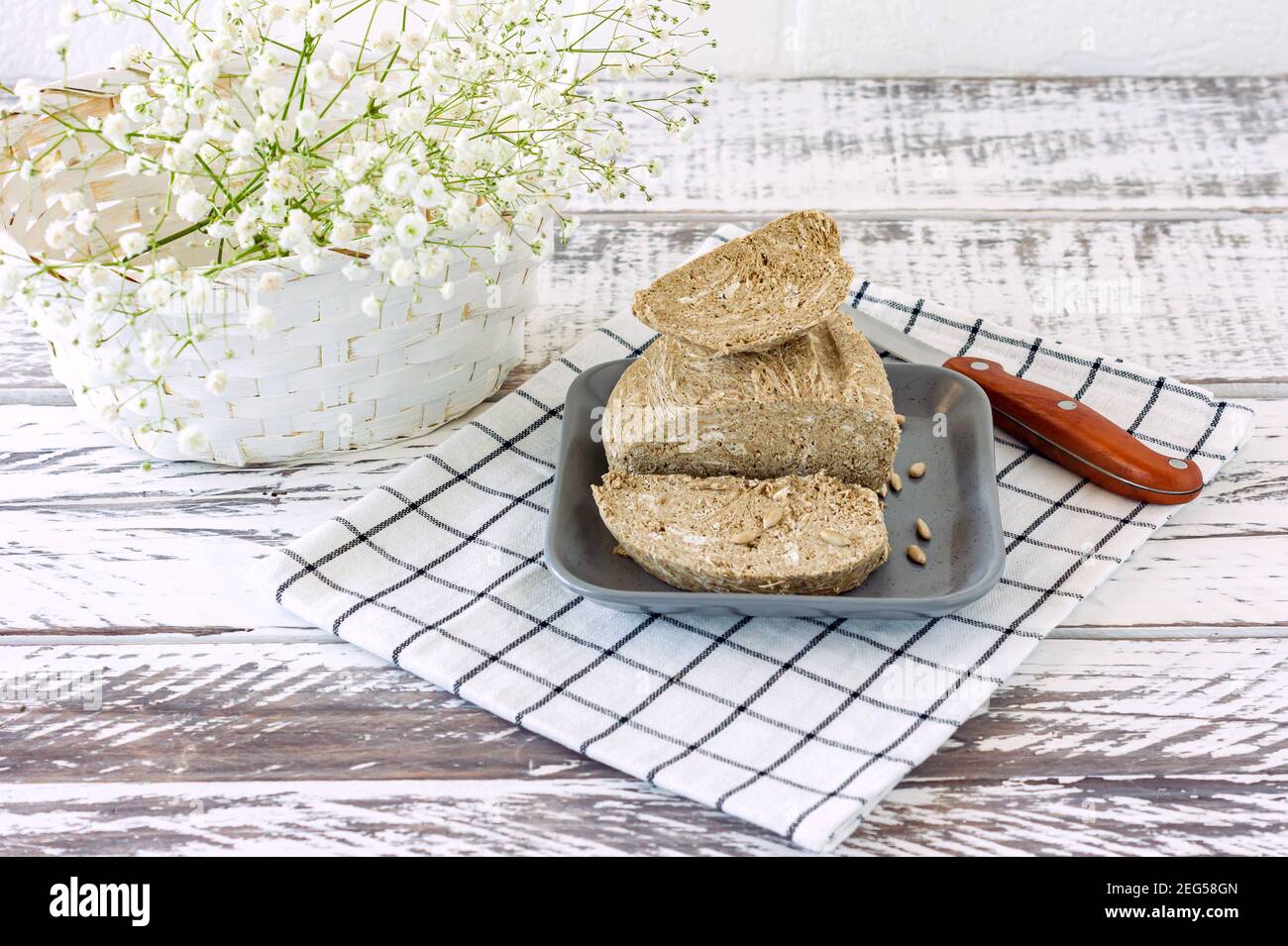 peanut halva on a plate on white wooden table. Oriental dessert from ...