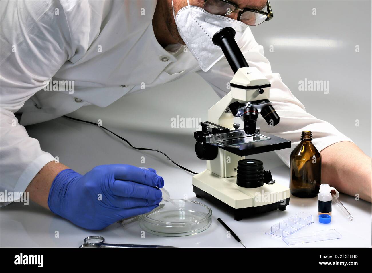 scientist looking through microscope Stock Photo - Alamy