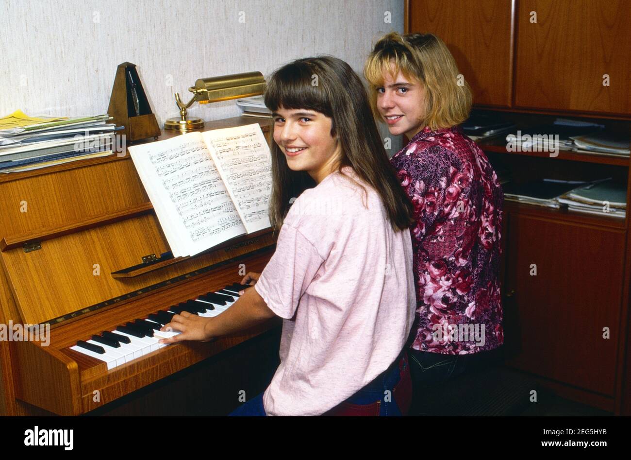 Verena Großer (hinten), deutsche Schauspielerin, mit Schwester Pamela am Klavier zuhause in ...