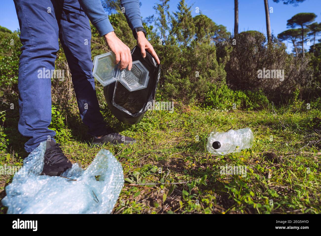 Man cleaning-up the forest of plastic garbage. Nature cleaning ...