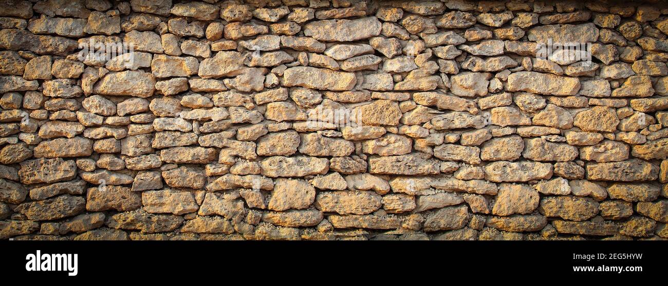 The old solid wall of rough stones as background Stock Photo - Alamy