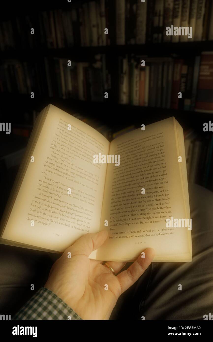Dreamlike soft focus image of man sitting holding an open book reading ...