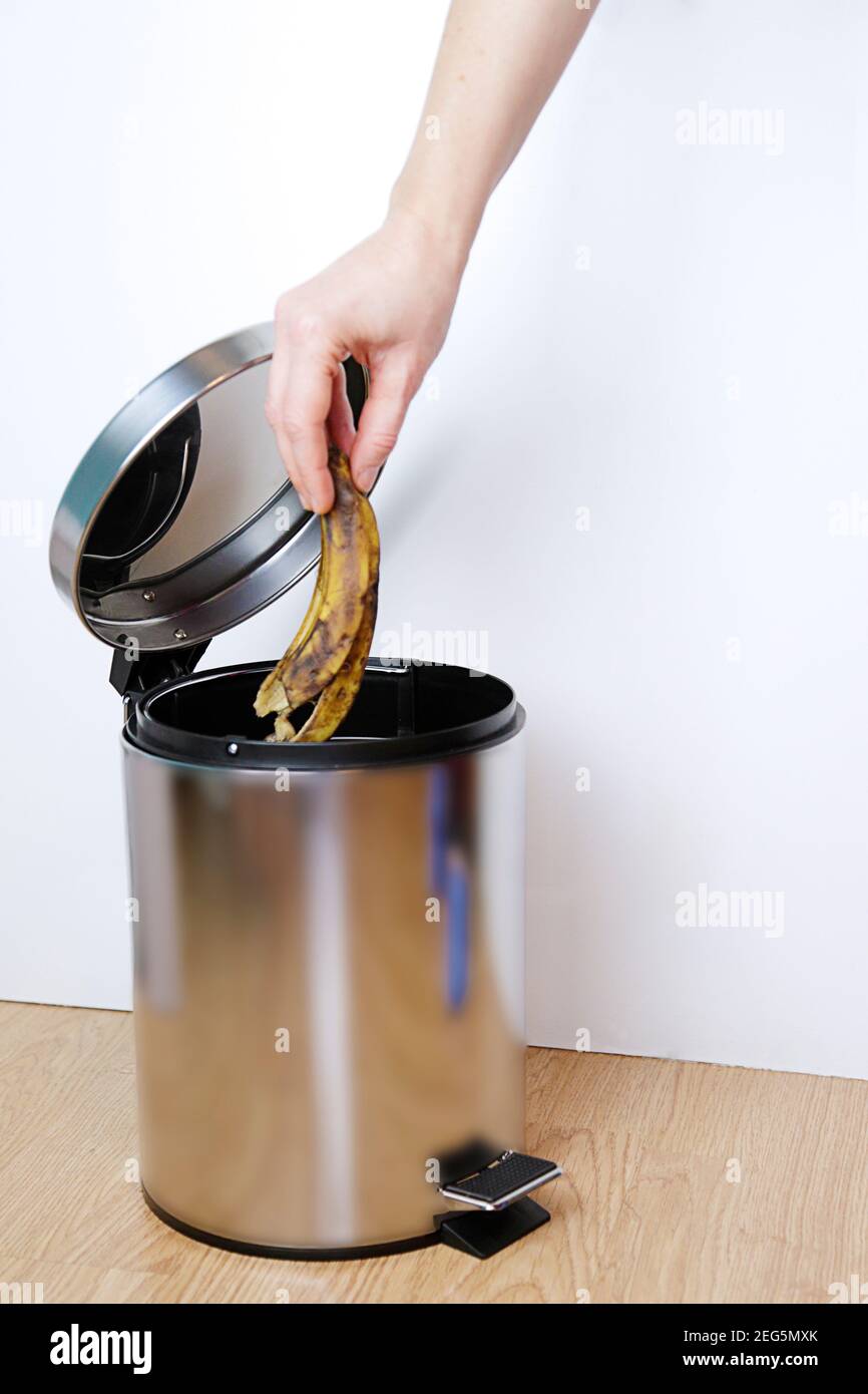 Woman hand throwing a banana peel into the garbage bin Stock Photo - Alamy
