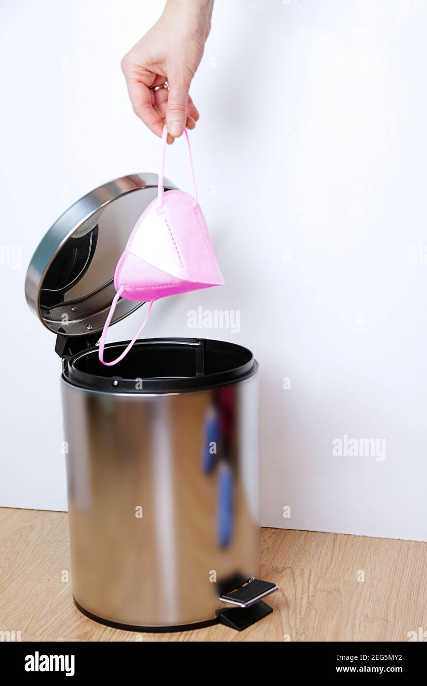 Woman hand throwing face mask into the garbage bin Stock Photo - Alamy