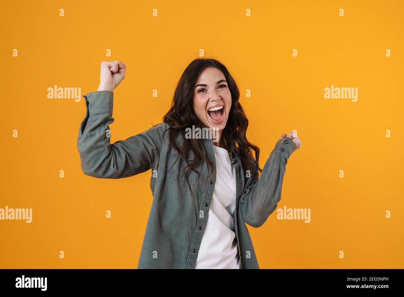 Excited beautiful girl screaming and making winner gesture on camera ...