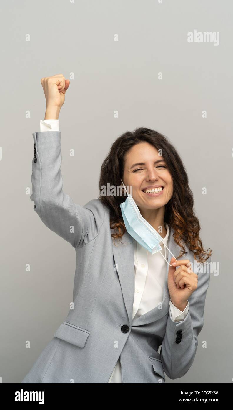 Studio portrait of happy business woman taking off mask from face ...
