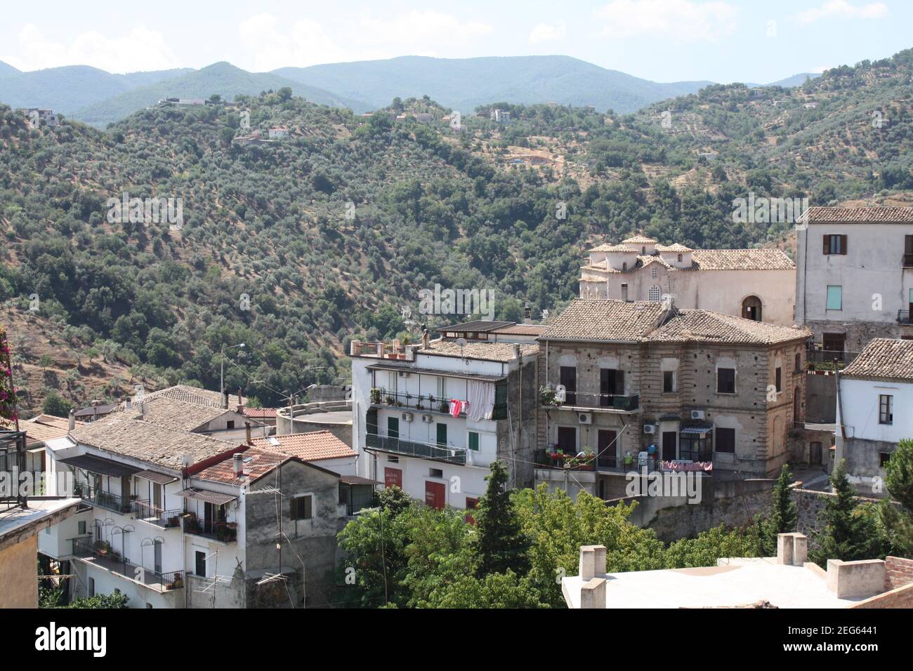 Aerial view of a small town with a forested hill in the background ...
