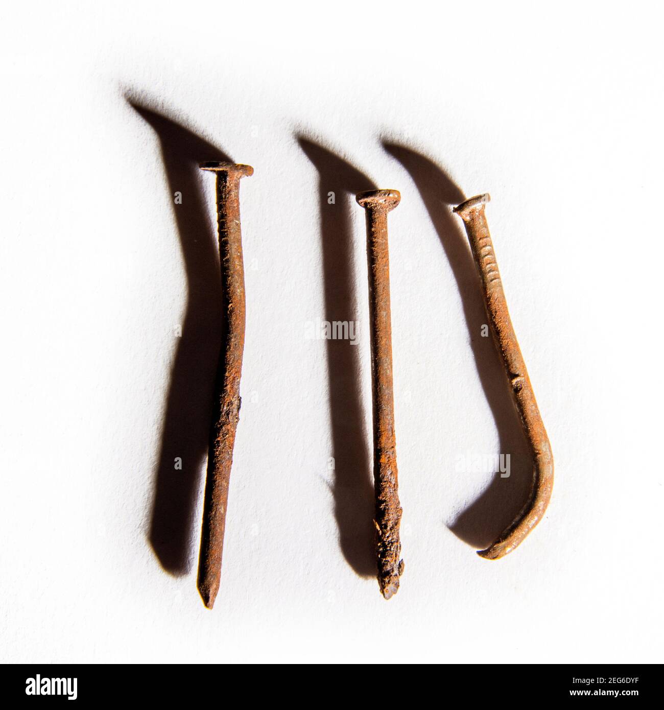 Various types of aged iron nails arranged on a white background ...