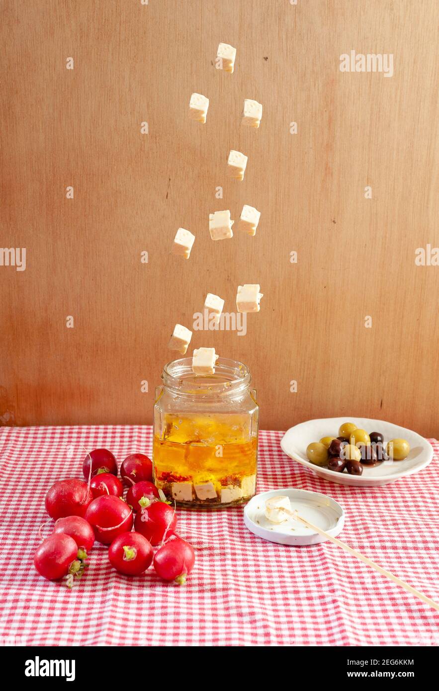 Vertical shot of feta cheese falling into glass jar Stock Photo - Alamy
