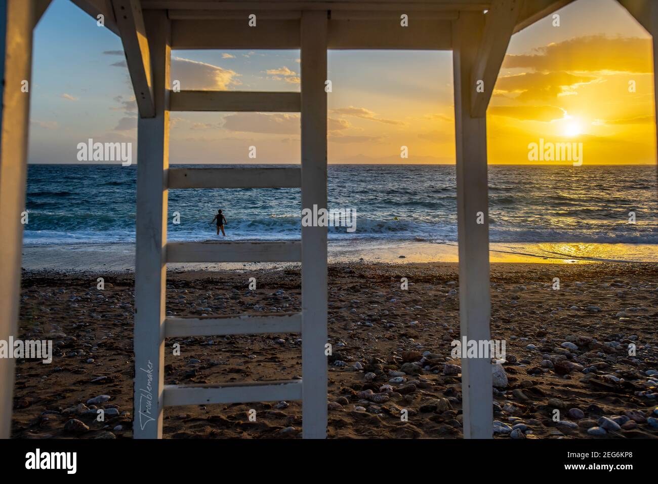 A swimmer getting ready to dive during sunset,as seen through a ...