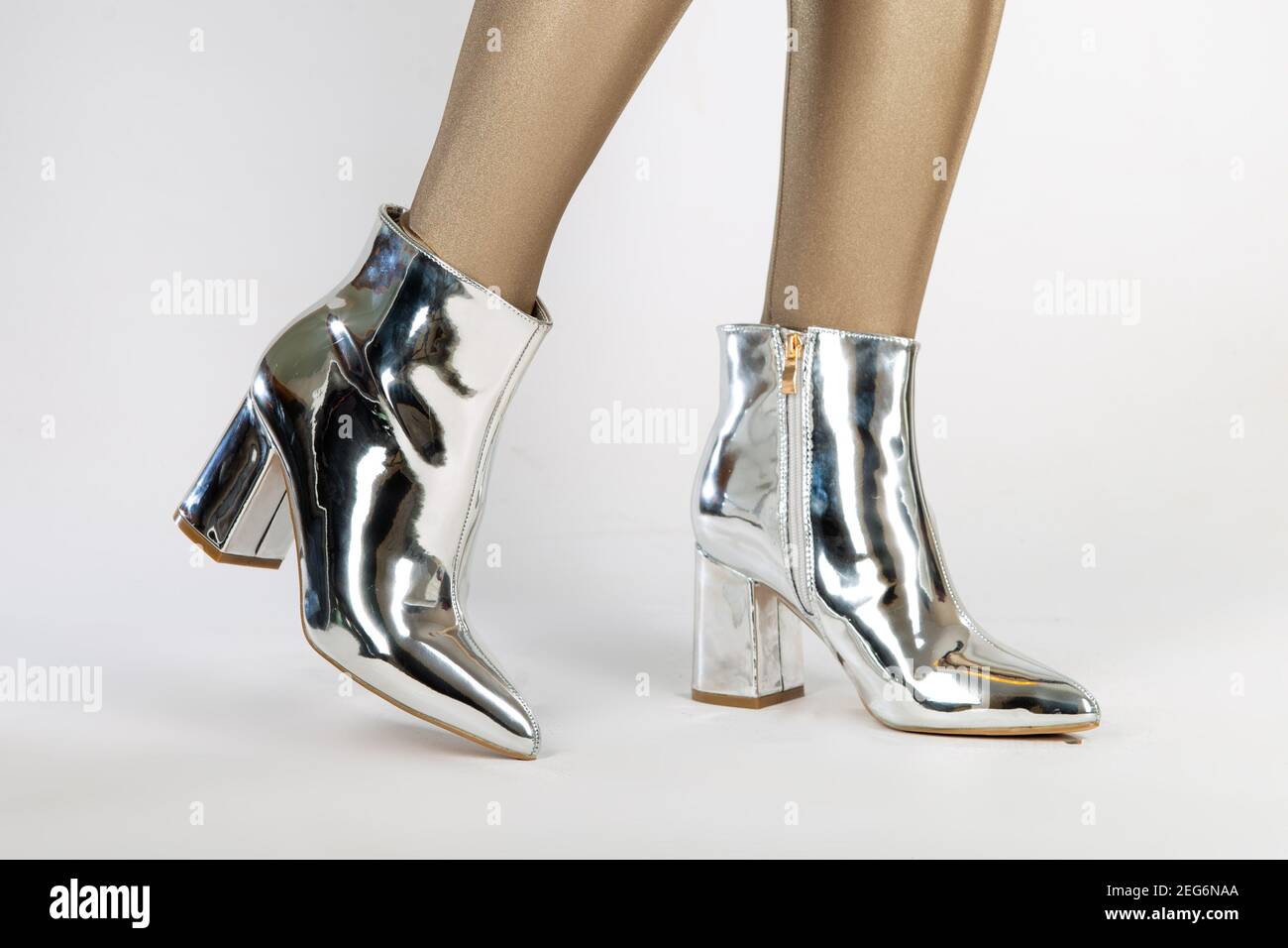 Female model wearing elegant silver winter boots in a studio against a ...