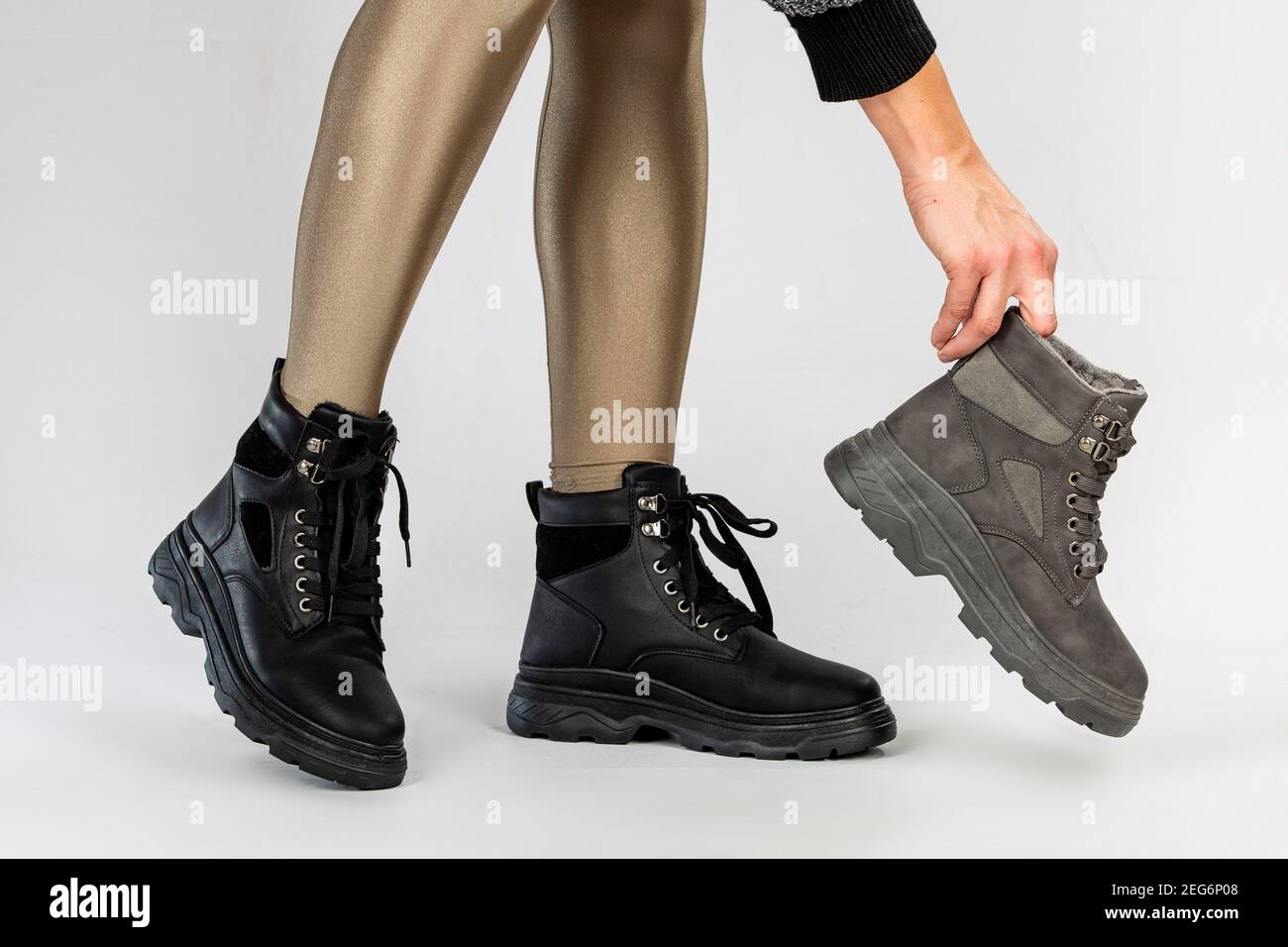Female model wearing black winter boots in a studio against a white ...