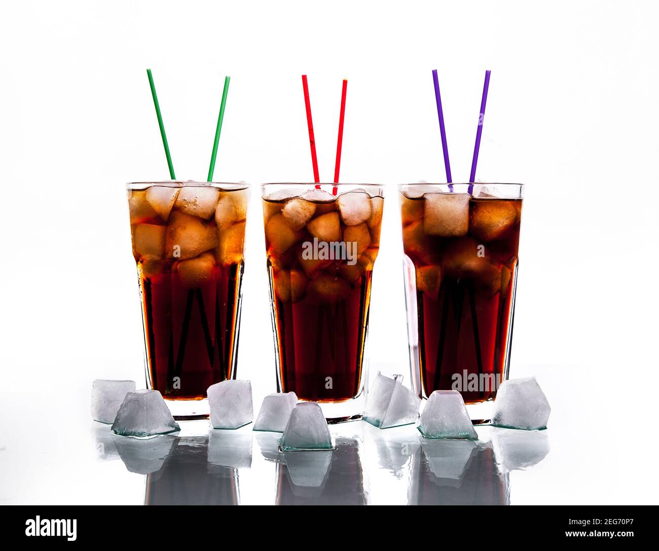 three glasses of cola with ice and straws on a white background. soft ...