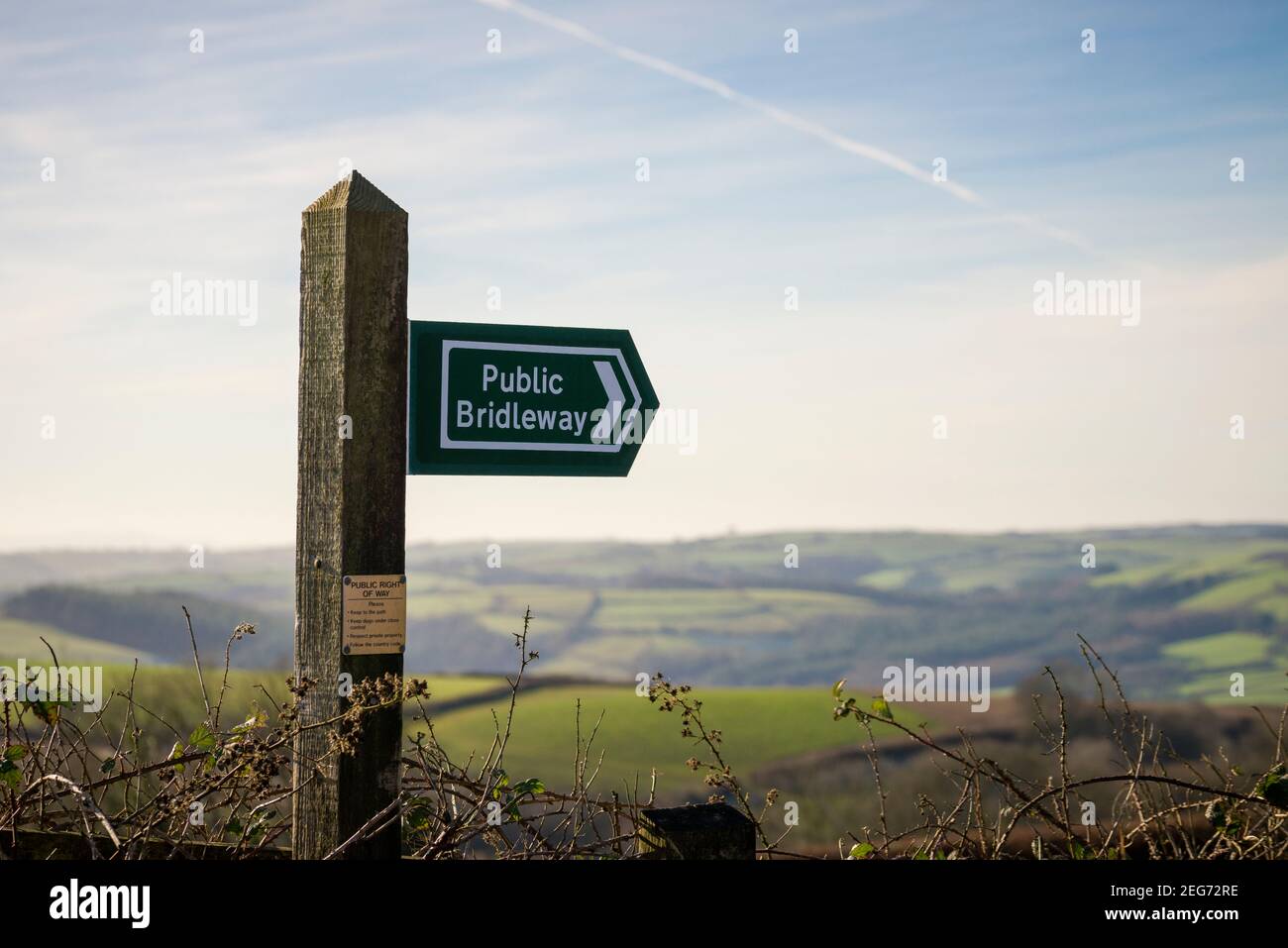 A public bridleway sign with the Exe Valley beyond in winter near ...