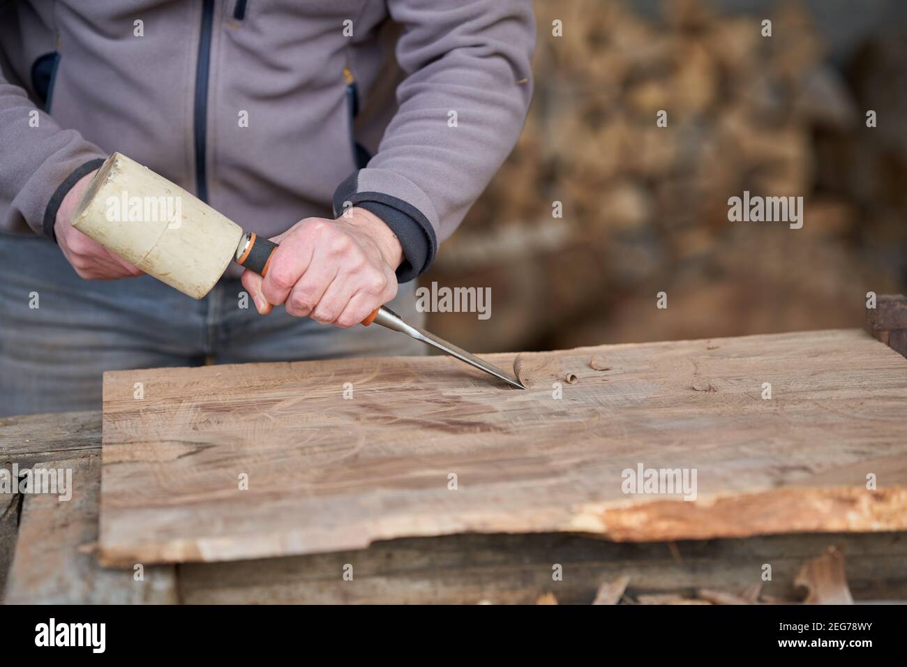 Carpenter working with hammer and chisel on a walnut wood Stock Photo ...