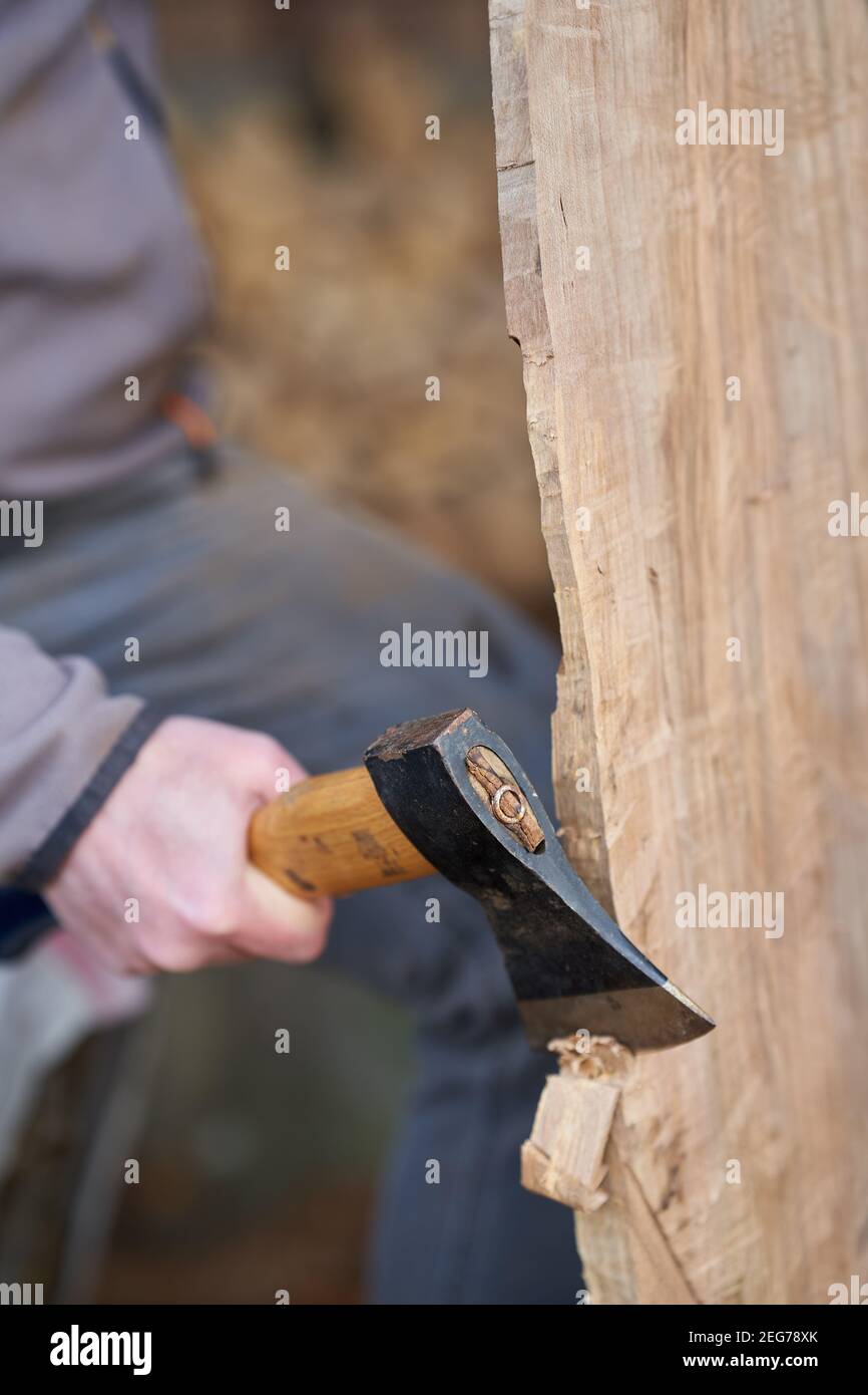 Carpenter using a hatchet to sculpt a walnut wood board Stock Photo - Alamy