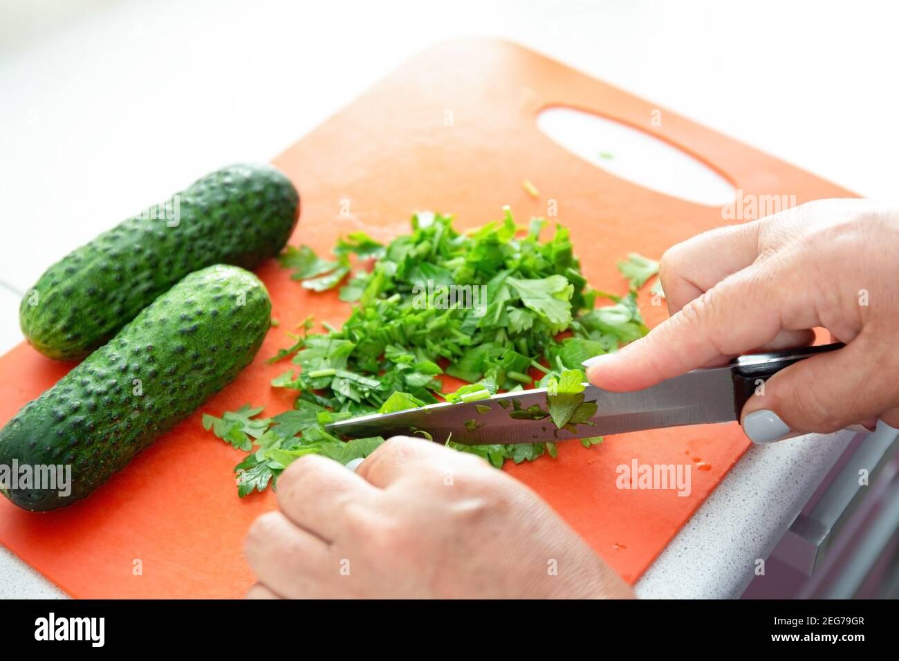 Woman hands cutting parsley on plastic board. Kitchen interier Stock ...