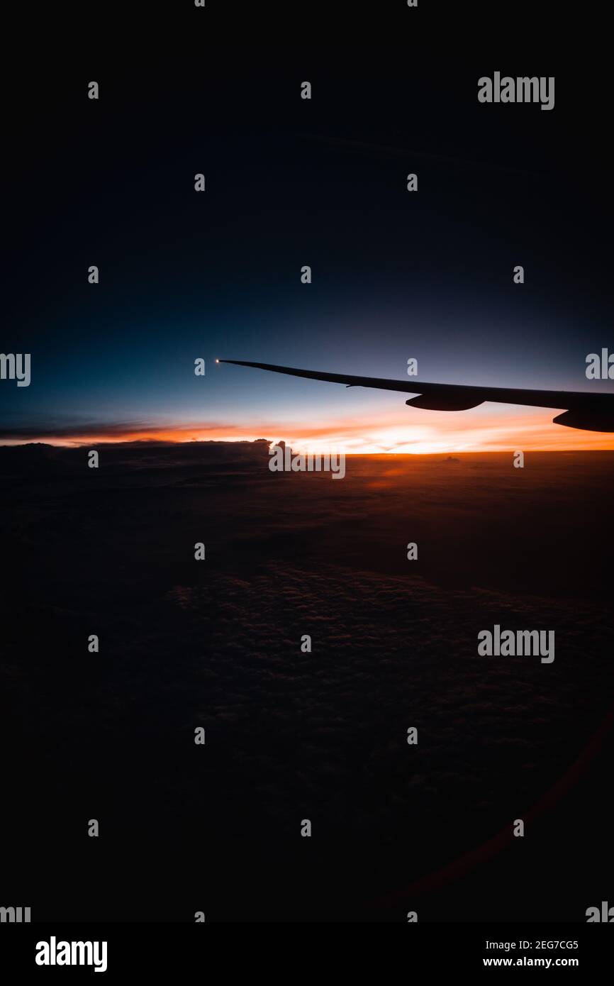 Vertical shot of airplane wings on the sky with a beautiful sunset ...