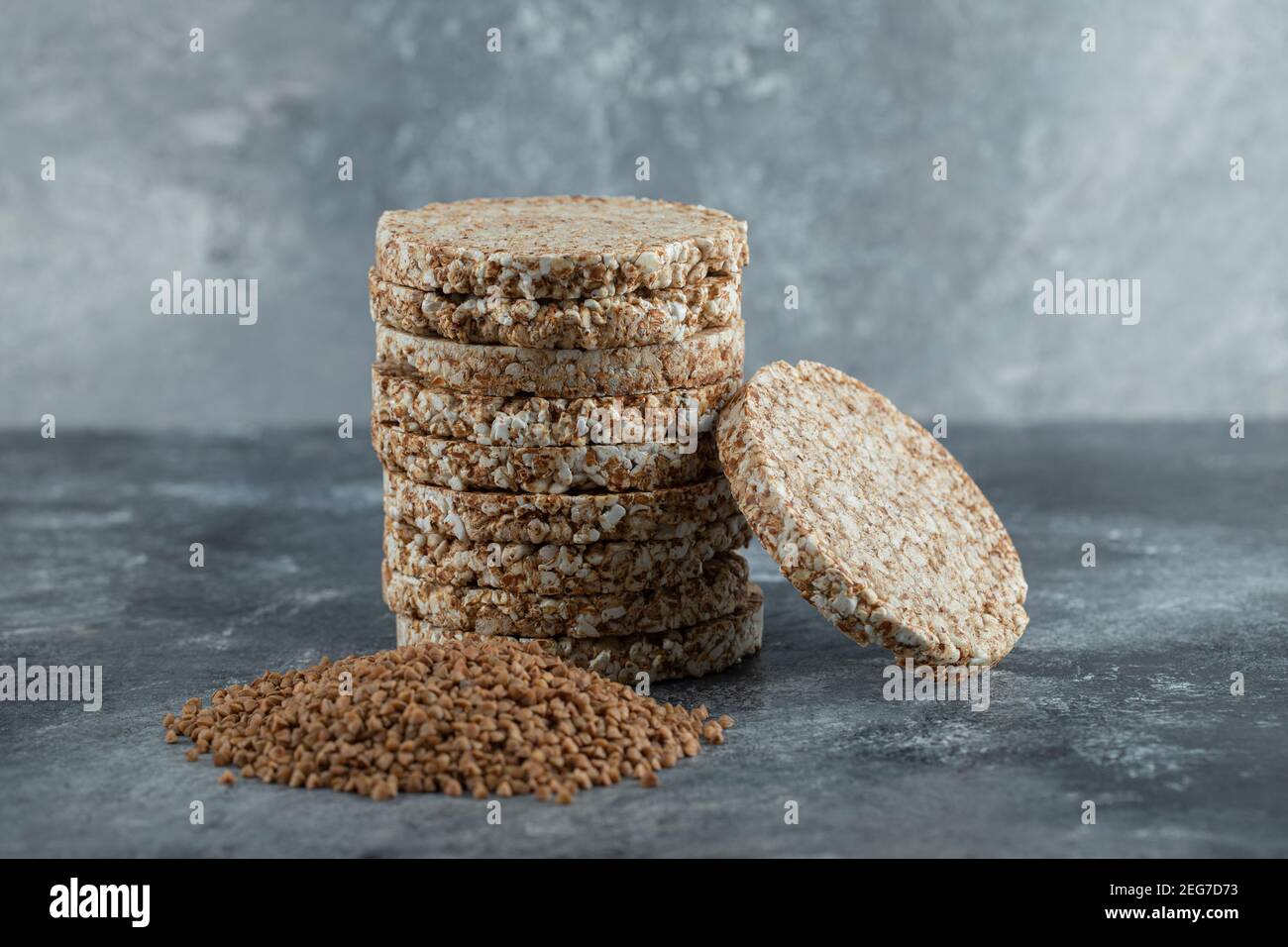 Stack of crispbread and pile of buckwheat on marble surface Stock Photo ...