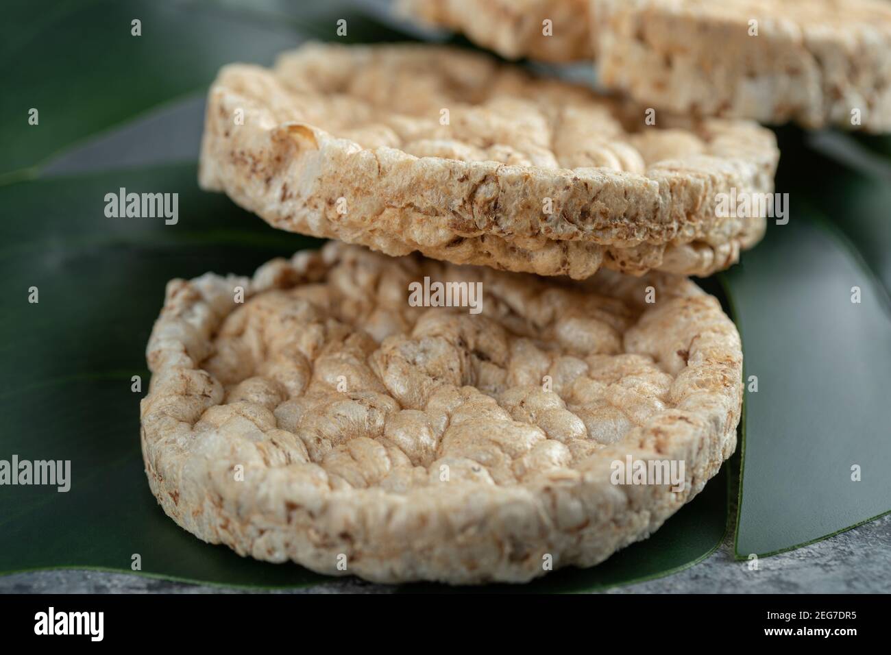 Three puffed rice cakes on green leaf Stock Photo - Alamy