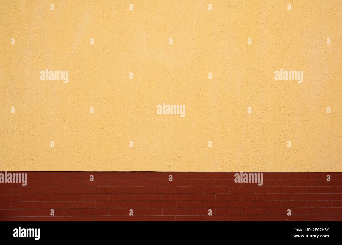 yellow wall with plaster and brown tiles below, exterior decoration of ...