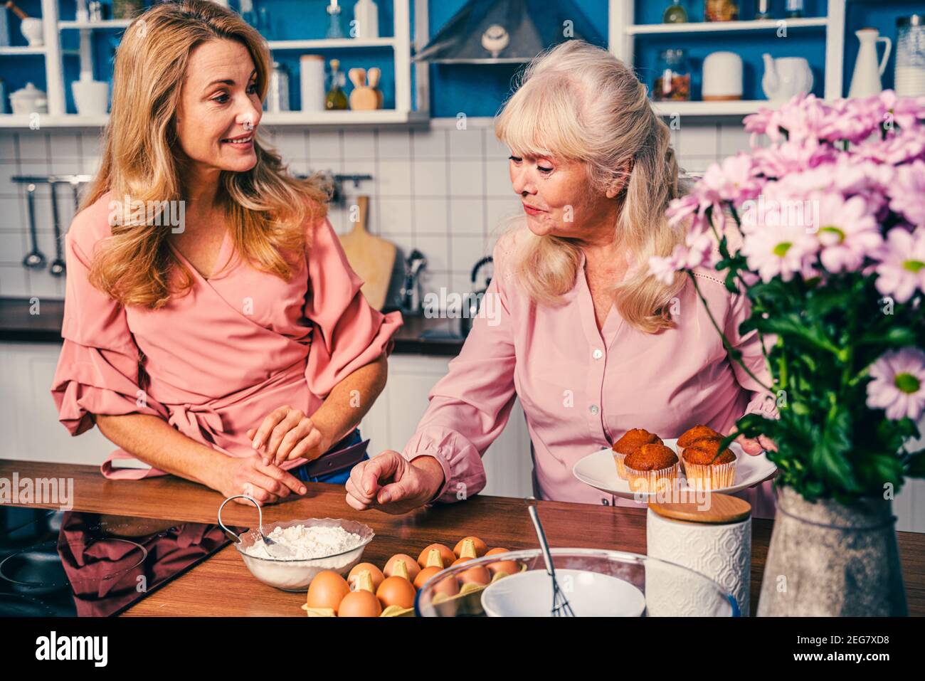 Beautiful senior woman and daughter baking in the kitchen - Grandmother ...