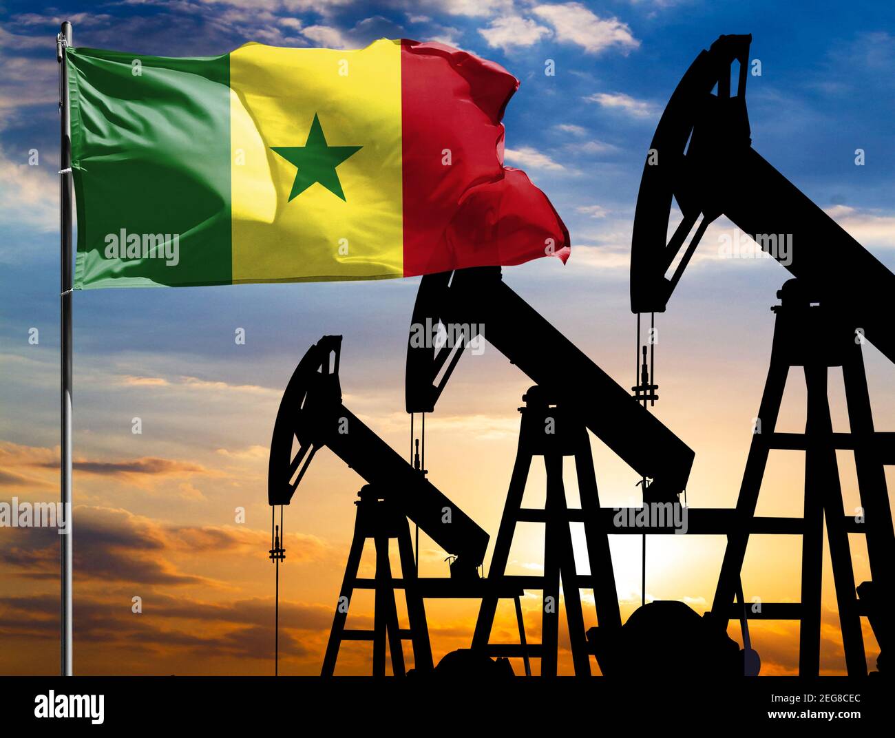 Oil rigs against the backdrop of the colorful sky and a flagpole with ...