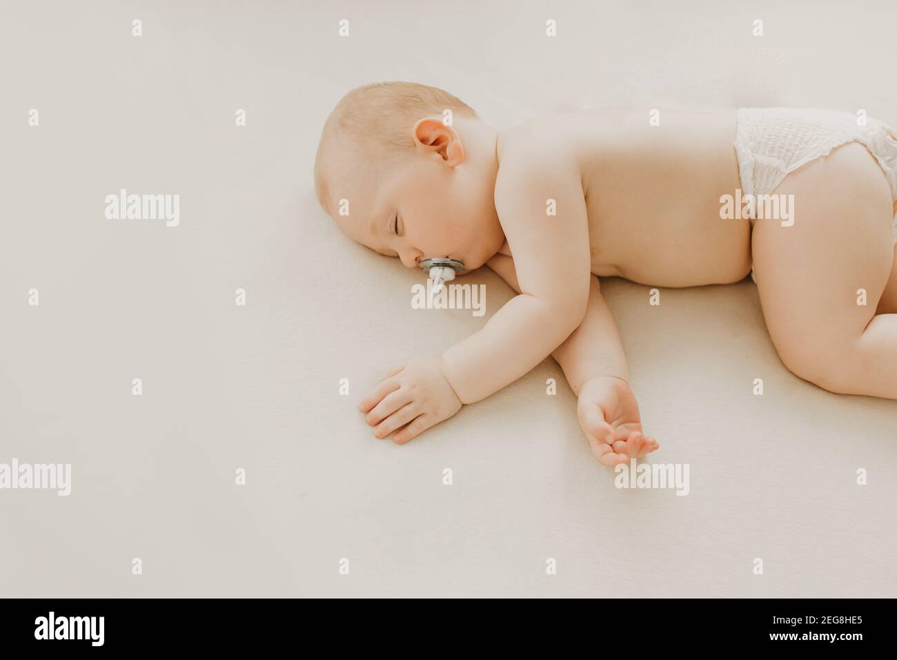 Sleeping newborn baby, in a diaper in the crib Stock Photo - Alamy