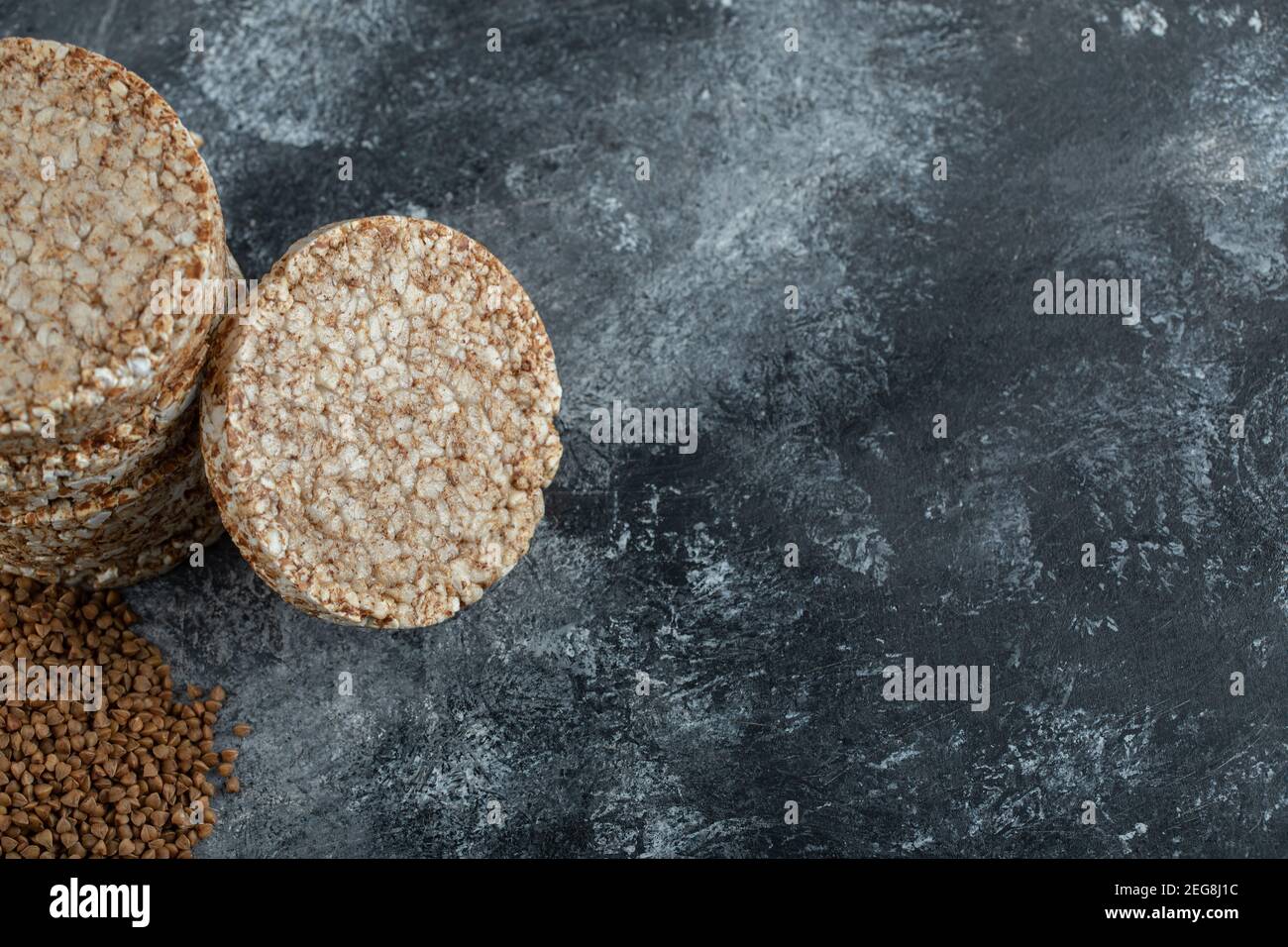 Stack of rice cakes and pile of buckwheat on marble surface Stock Photo ...