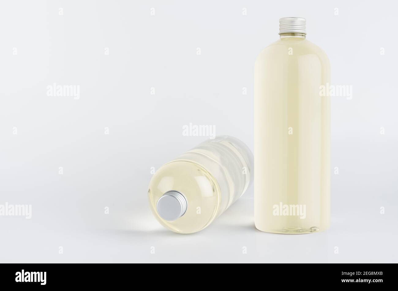 Set of two transparent plastic tall bottles standing and lying with ...