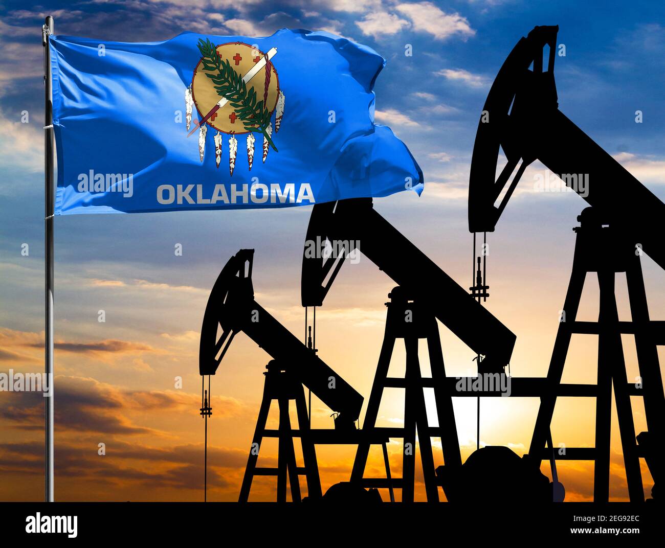 Oil rigs against the backdrop of the colorful sky and a flagpole with ...