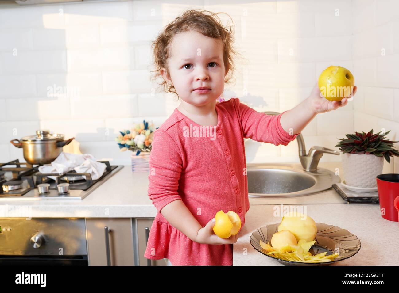 Adorable little child girl helping and baking apple pie in home''s ...