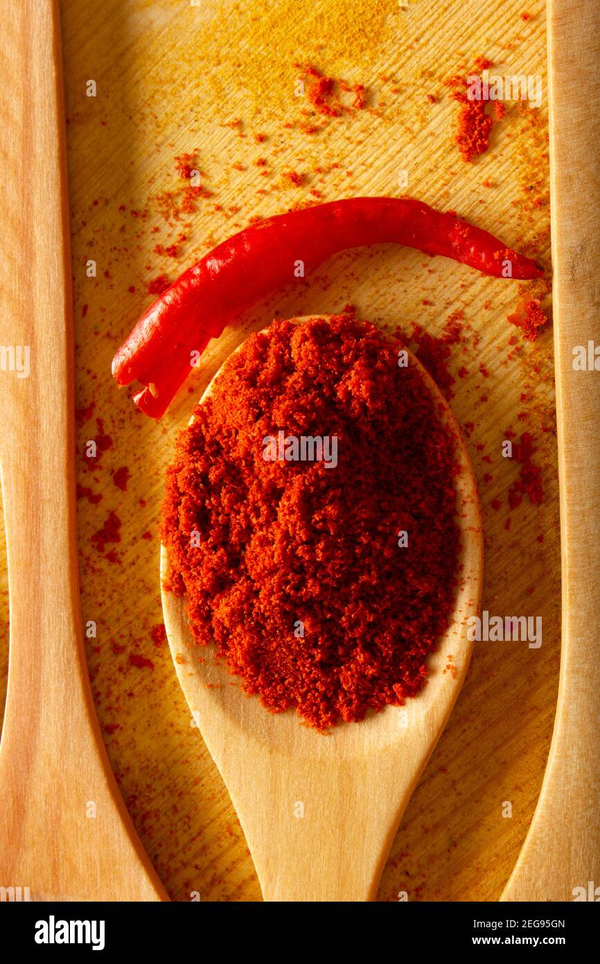 Red powder pepper in wooden spoon, studio shot Stock Photo - Alamy
