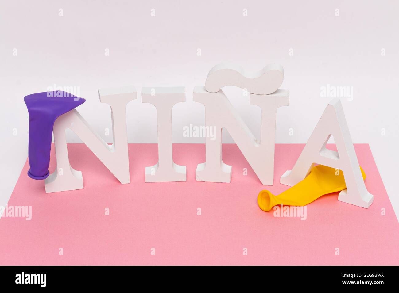 Colorful background with Spanish "NINA" writing and two balloons Stock ...