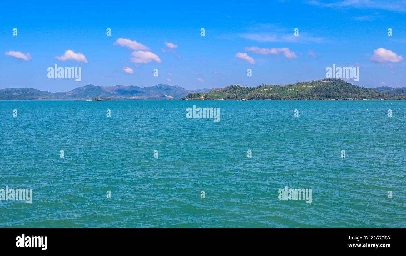 Beautiful view of a landscape surrounded by mountains on the wavy sea ...