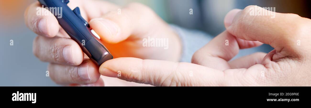closeup of a young caucasian man about to measure his blood glucose ...