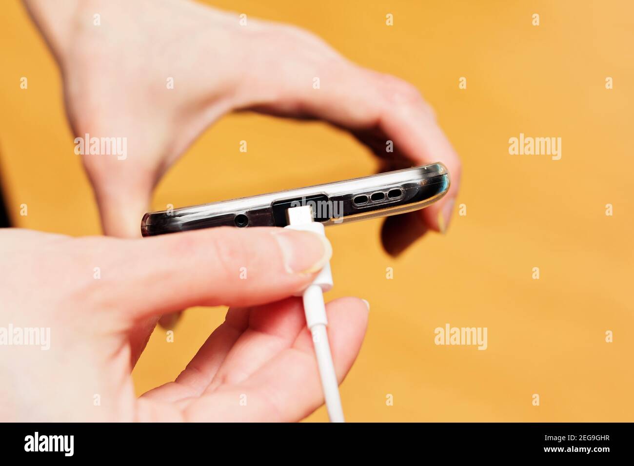 The woman connects the charger to her smartphone Stock Photo - Alamy