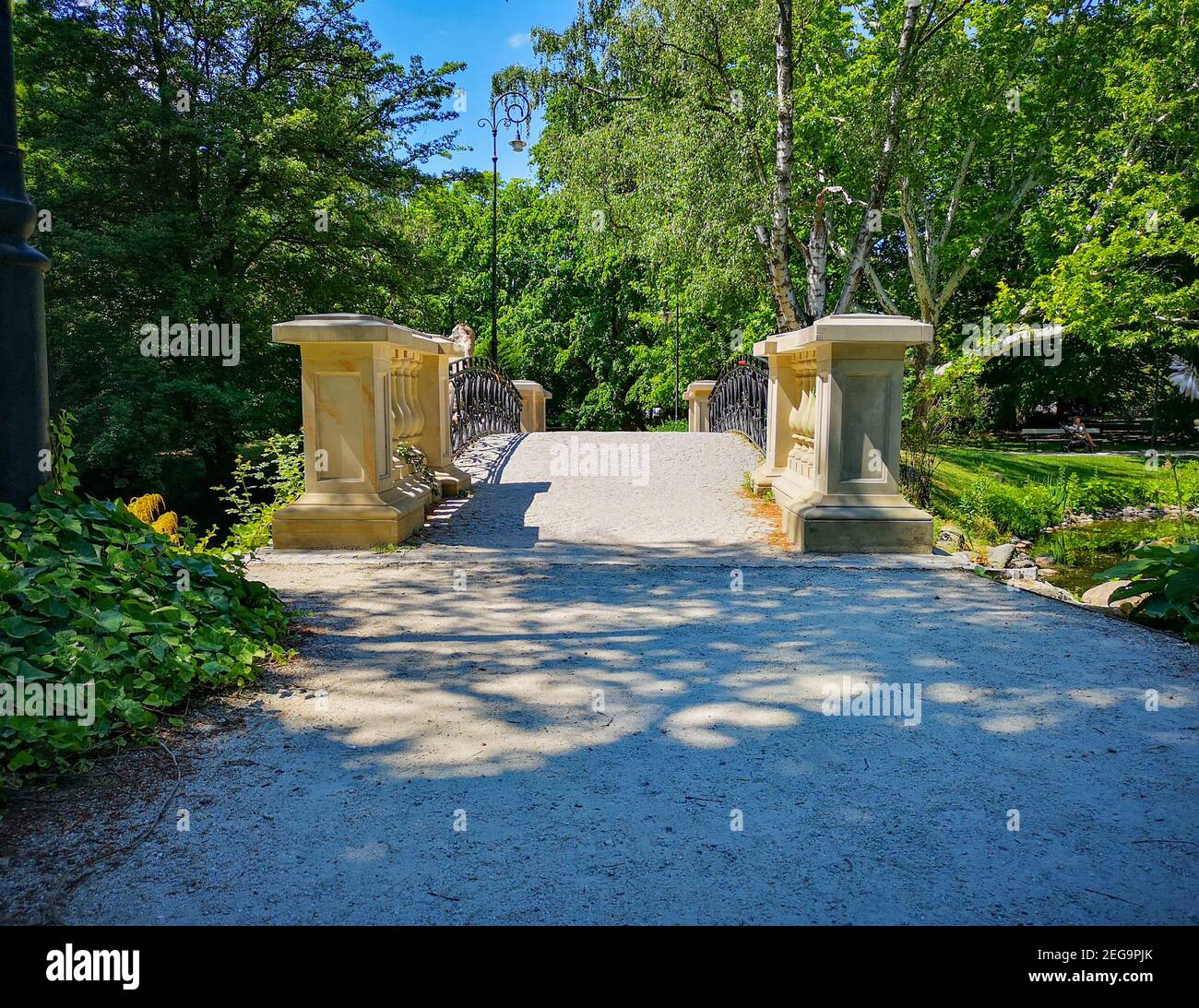 Small concrete bridge over lake with metal fence Stock Photo - Alamy